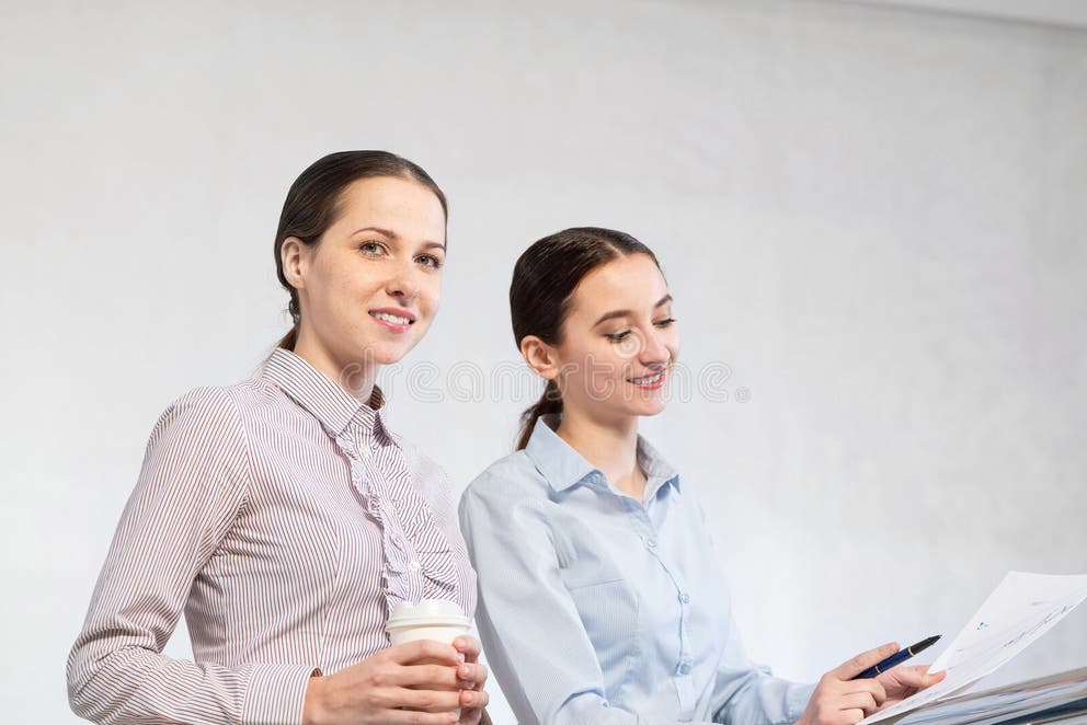 Two Young Women Discuss Documents Stock Photo - Image of caucasian ...