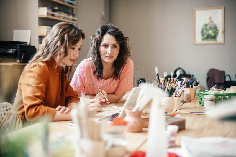 Two Young Women Discussing Project Ideas, Moodboard Using Laptop Stock ...