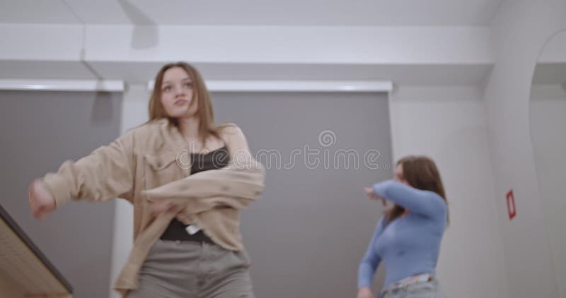 Two Young Women Energetically Practice a Hip-Hop Dance Routine in a ...