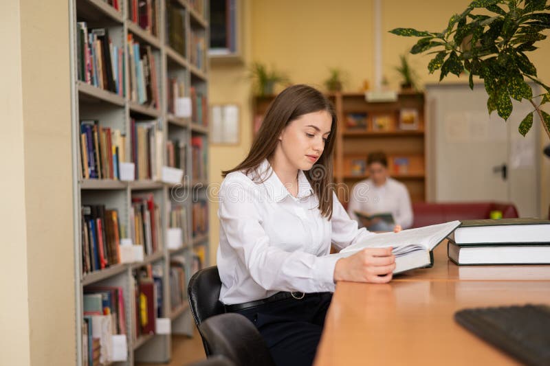 Two Young Women Reading Books in a Public Library. Stock Image - Image ...