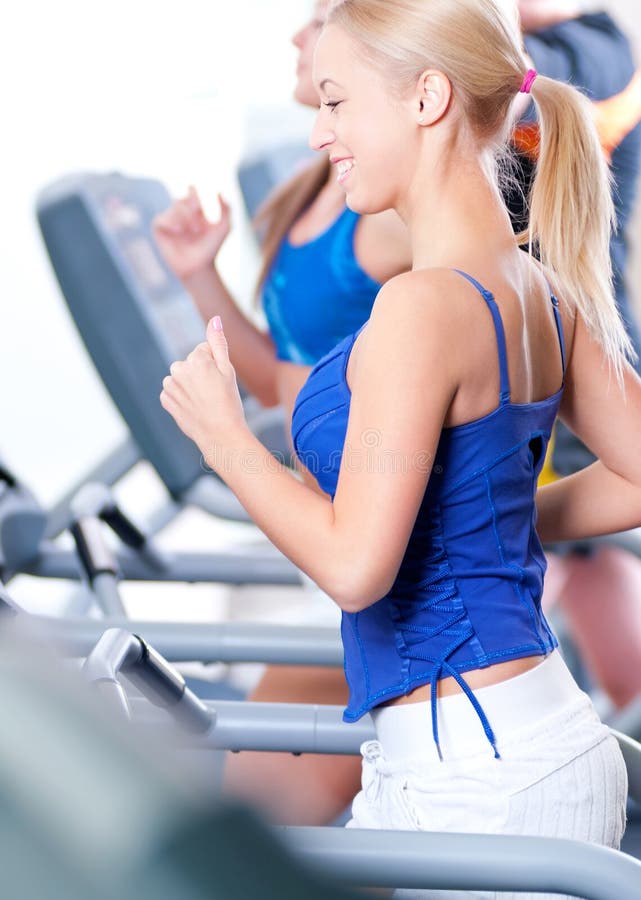 Two Young Women Run on Machine in the Gym Stock Photo - Image of ...