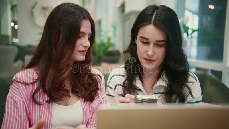 Women Discussing Over a Smartphone in a Cafe Stock Footage - Video of ...