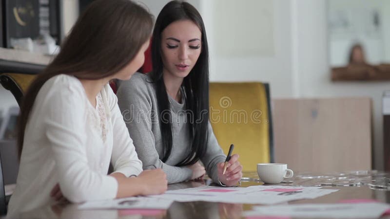 Two Young Women Sitting at a Table in the Office. Stock Video - Video ...