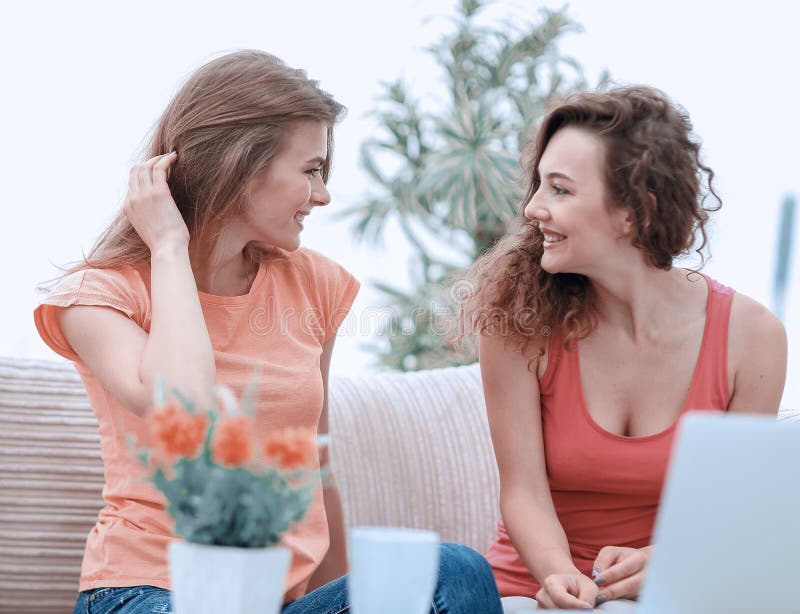 Two Young Women Talking and Sitting Down at the Coffee Table Stock ...