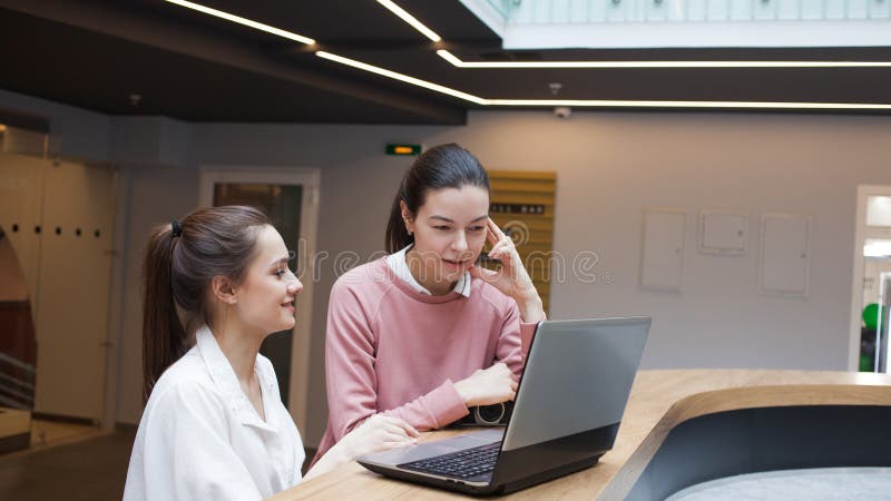 Two Young Women at Work are Engaged in Discussing a Work Project. Stock ...
