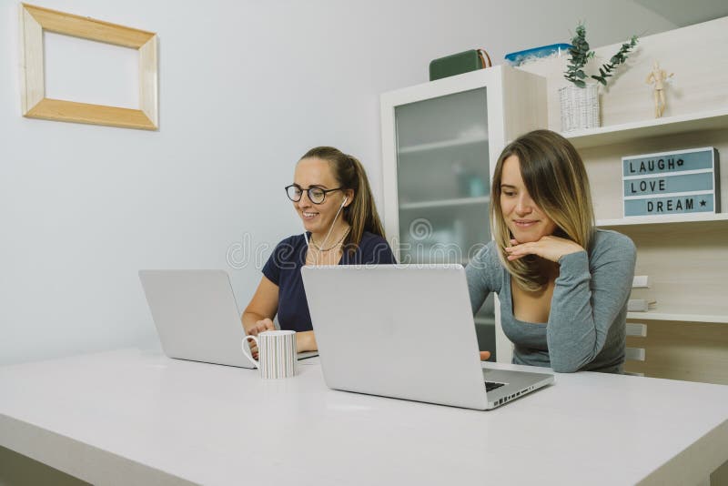 Two Young Women Working at Laptop at Office Stock Photo - Image of ...