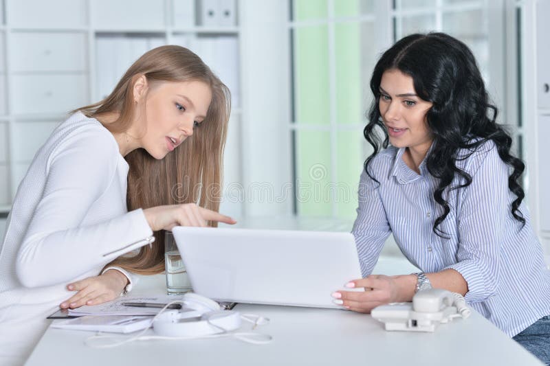 Portrait of Two Young Women Working at Office with Laptop Stock Photo ...