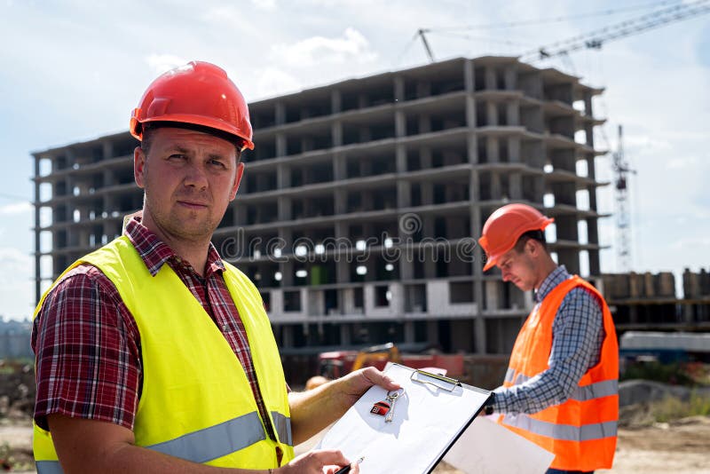 Two Young Workers in Uniform are Considering a Project To Build a New ...