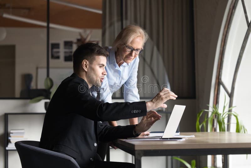 Two Younger and Elder Business Professionals Discussing Project Tasks ...