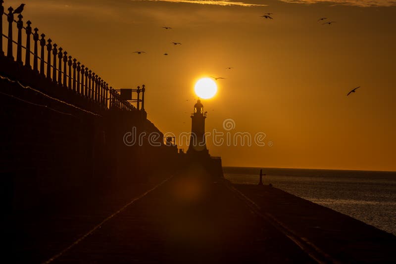 Tynemouth Pier and the Lighthouse through the Metal Railings with a ...