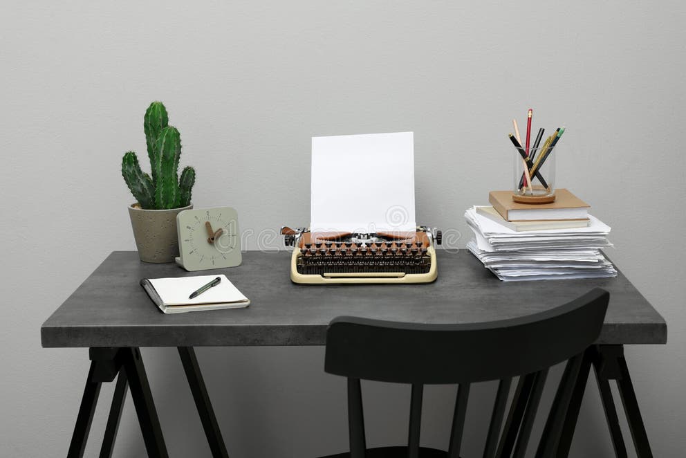 Typewriter and Stack of Papers on Dark Table Near Light Grey Wall ...