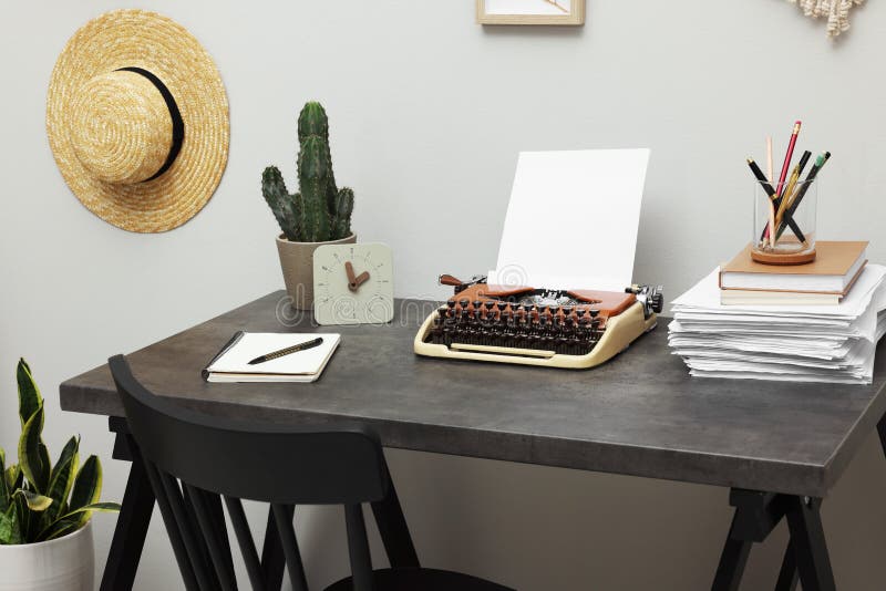 Typewriter and Stack of Papers on Dark Table in Room. Writer`s ...