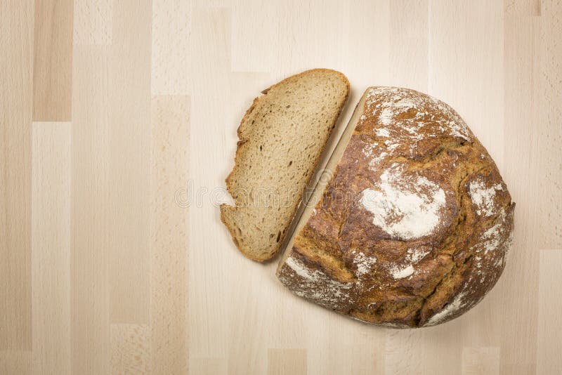 A Typical German Loaf of Bread and One Slice Lying on a Wooden Beech ...