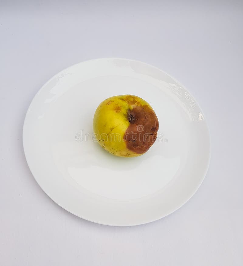 Ugly Damaged Yellow Apple on a White Plate on the Table Stock Photo ...
