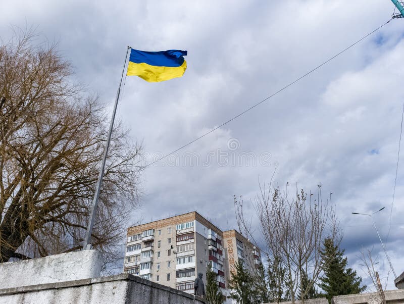 A Ukrainian Flag Flying in Front of a Tall Building Stock Photo - Image ...