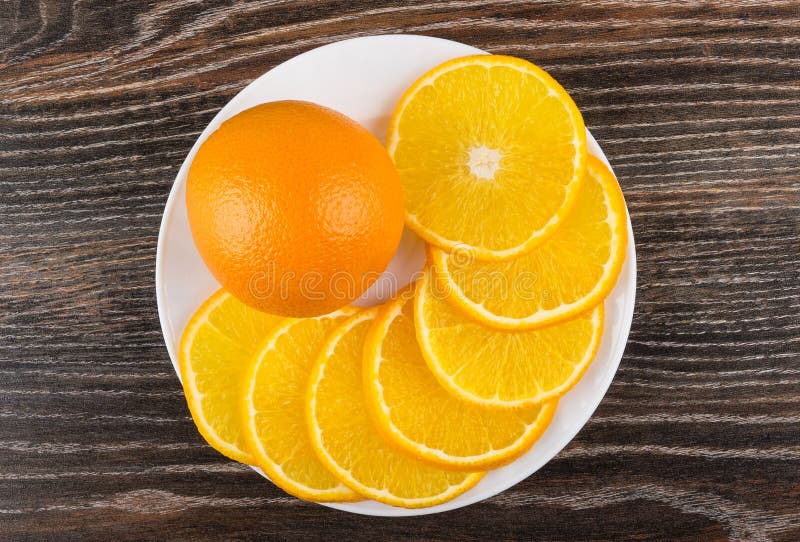 Uma Laranja Inteira E Fatias De Laranjas No Prato Branco Foto de Stock ...