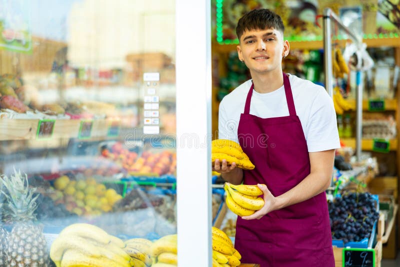 Un Joven Trabajador De Un Supermercado Europeo Recogiendo Bananas ... Un Joven Trabajador De Un Supermercado Europeo Recogiendo Bananas ...