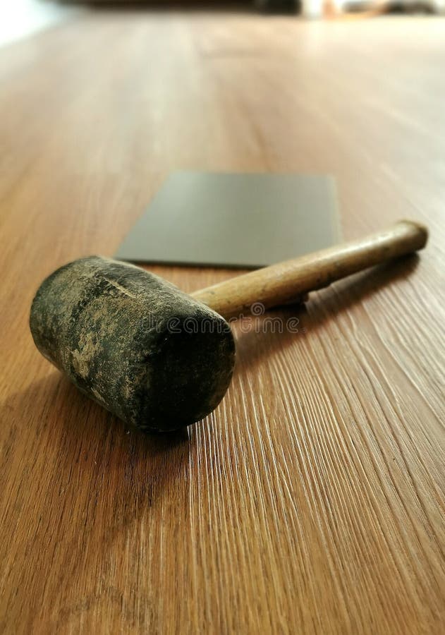 Un Martillo De Mallet Sobre Baldosas De Madera De Caucho Spc. Foto de ...