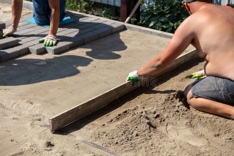 Un Ouvrier Pond Du Sable Pour Paver Des Dalles. Image stock - Image du ...
