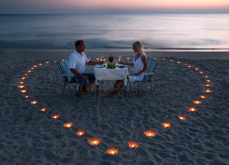 Un Par Joven Comparte Una Cena Romántica En La Playa Imagen De Archivo