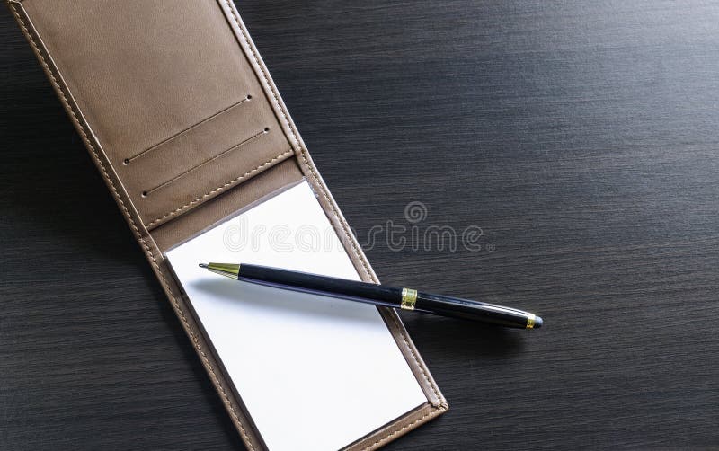 Un Stylo Et Une Petite Note Quotidienne Sur Une Table Noire Photo stock ...
