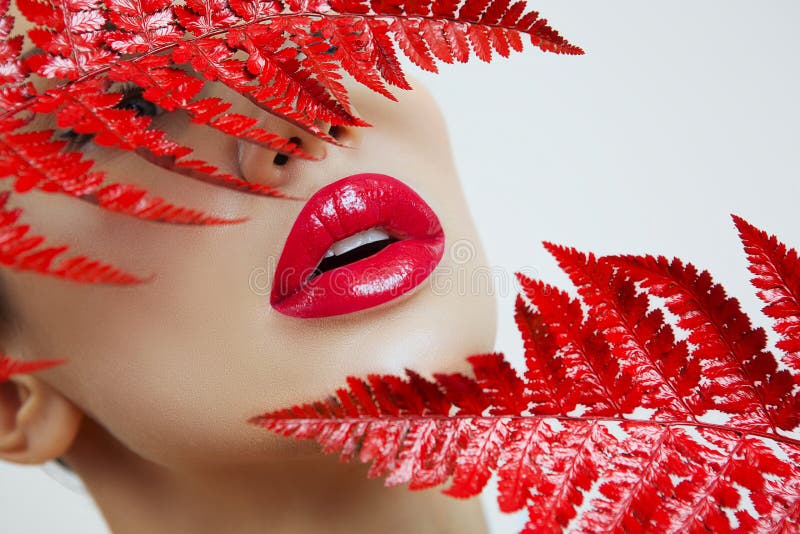 Una Donna Con Le Labbra Rosse Sensuali E Una Felce Immagine Stock