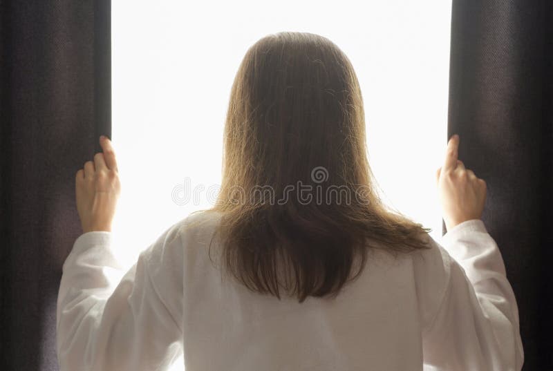 Una Joven Con Un Abrigo Blanco Se Pone De Pie En La Ventana Y Abre Las Cortinas Con Las Manos