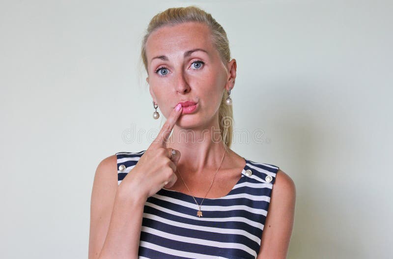 Una Mujer Pasmada Con Un Finger Al Lado De Su Boca Foto de archivo ...