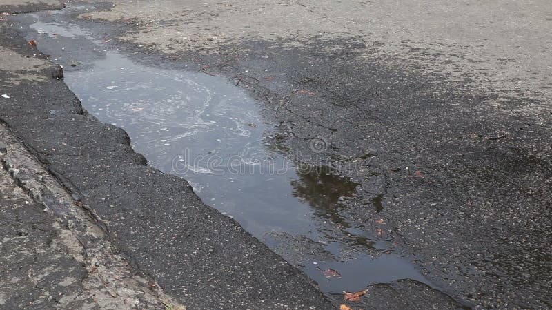 Una Pozza Di Acqua Sulla Strada Stock Footage - Video di pozza, asfalto ...