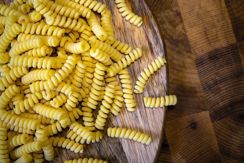 Uncooked Curly Pasta on Wooden Table Background. Stack of Traditional ...