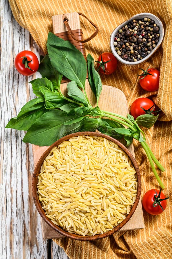 Uncooked Orzo Paste. Recipe for Risoni with Basil Leaves, Tomatoes and ...
