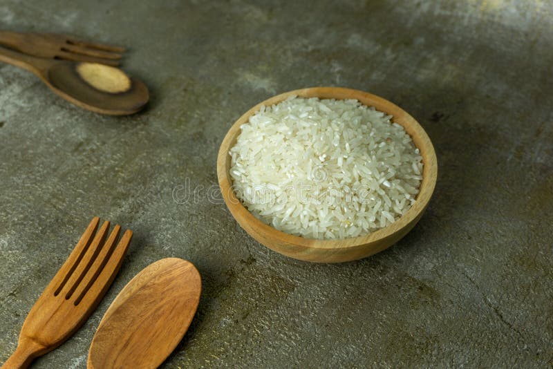Uncooked Rice or Dry Rice. Raw Rice in Wooden Bowl with Wooden Spoon ...