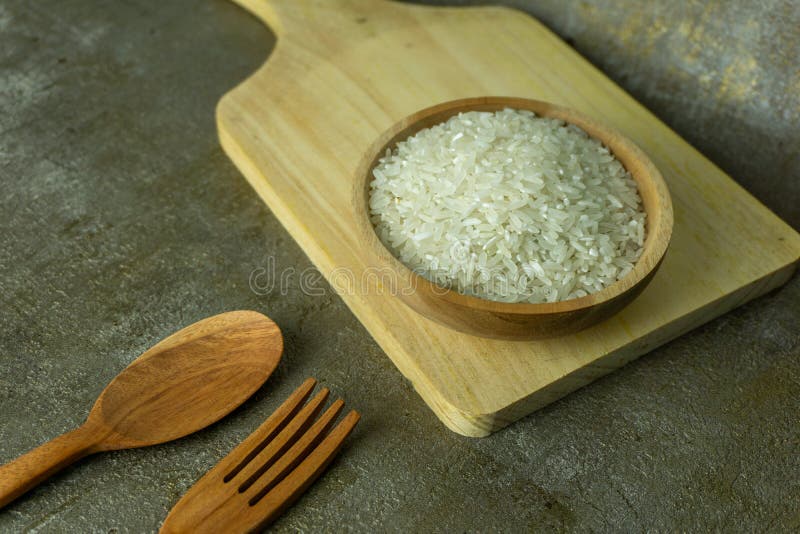 Uncooked Rice or Dry Rice. Raw Rice in Wooden Bowl with Wooden Spoon ...