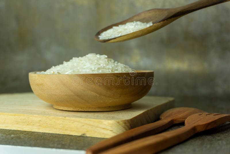 Uncooked Rice or Dry Rice. Raw Rice in Wooden Bowl with Wooden Spoon ...