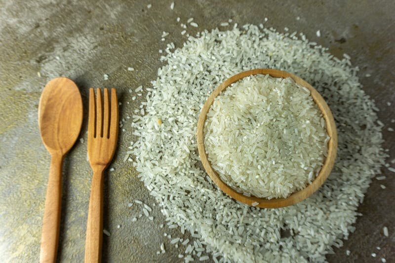 Uncooked Rice or Dry Rice. Raw Rice in Wooden Bowl with Wooden Spoon ...