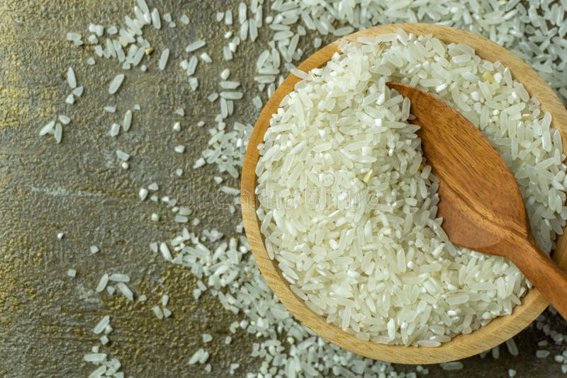 Uncooked Rice or Dry Rice. Raw Rice in Wooden Bowl with Wooden Spoon ...