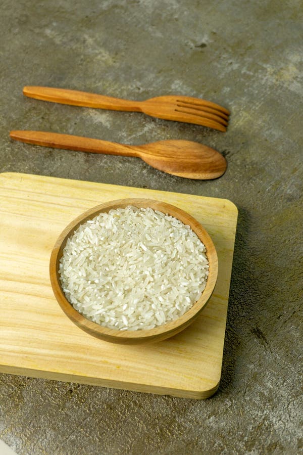 Uncooked Rice or Dry Rice. Raw Rice in Wooden Bowl with Wooden Spoon ...