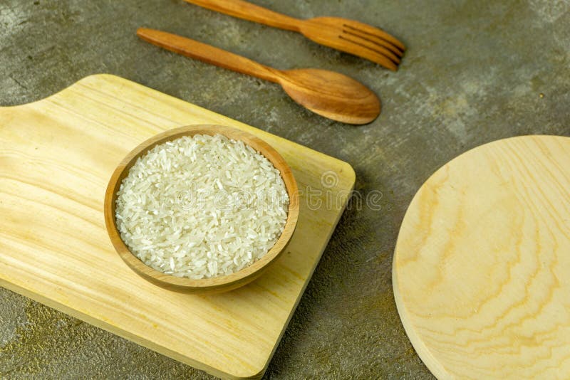 Uncooked Rice or Dry Rice. Raw Rice in Wooden Bowl with Wooden Spoon ...