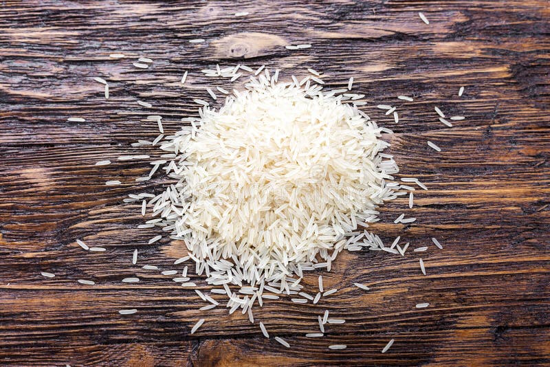 Uncooked Rice in a Wooden Spoon and a Clay Plate Stock Photo - Image of ...