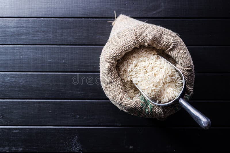 Uncooked White Rice in Burlap Sack on Black Table Stock Image - Image ...