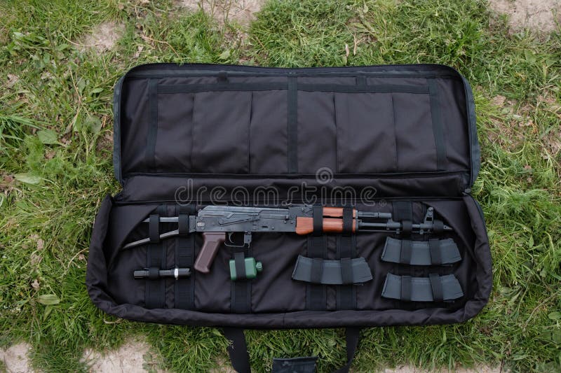 Uncovered Gun Case with AK-47, Magazines, and Flashlight Lying on the ...