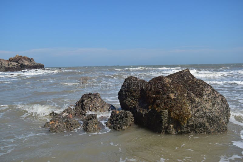 Under the Blue Sky, the Waves Beat the Rocks on the Beach Stock Image ...