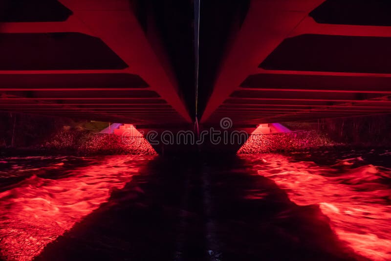 Under a Red Illuminated Bridge Over a Turbulent River Rapids Stock ...