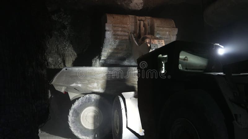 Underground Loader Loads Ore Mass into an Underground Dump Truck Stock ...