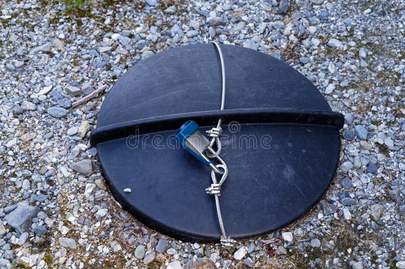 An Underground Tank`s Lid is Secured with a Steel Cable and a Lock ...