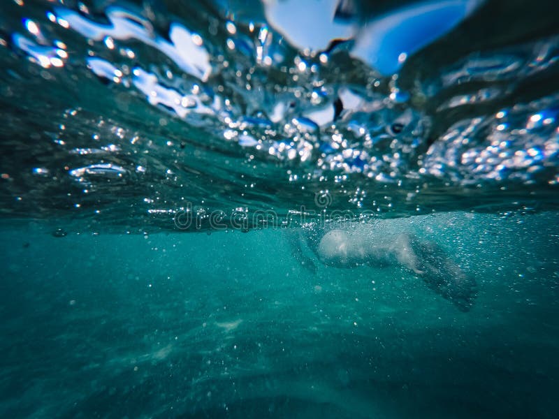 An Underwater Shot Capturing a Swimmer Immersed in the Clear Blue Ocean ...
