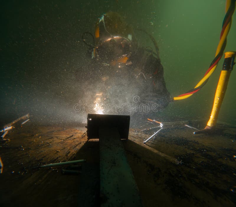 Underwater Welding in Vibrant Coral Reef with Fish Swimming Around ...