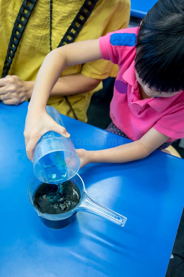 Une Fille Versant La Solution Chimique Bleue Dans La Solution Acide Et ...