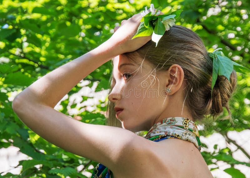 Une Jeune Fille Dans Une Robe Avec La Nudité Soutient La Valeur Dans Le Feuillage Dans Les