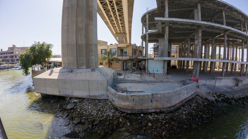 Unfinished Building by the River with Overhead Bridge Stock Image ...